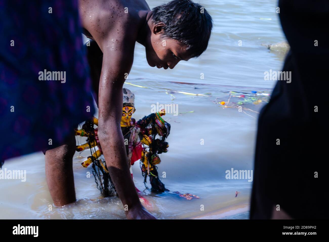 Children bringing up the immersed idol fom ganges and trying to ...
