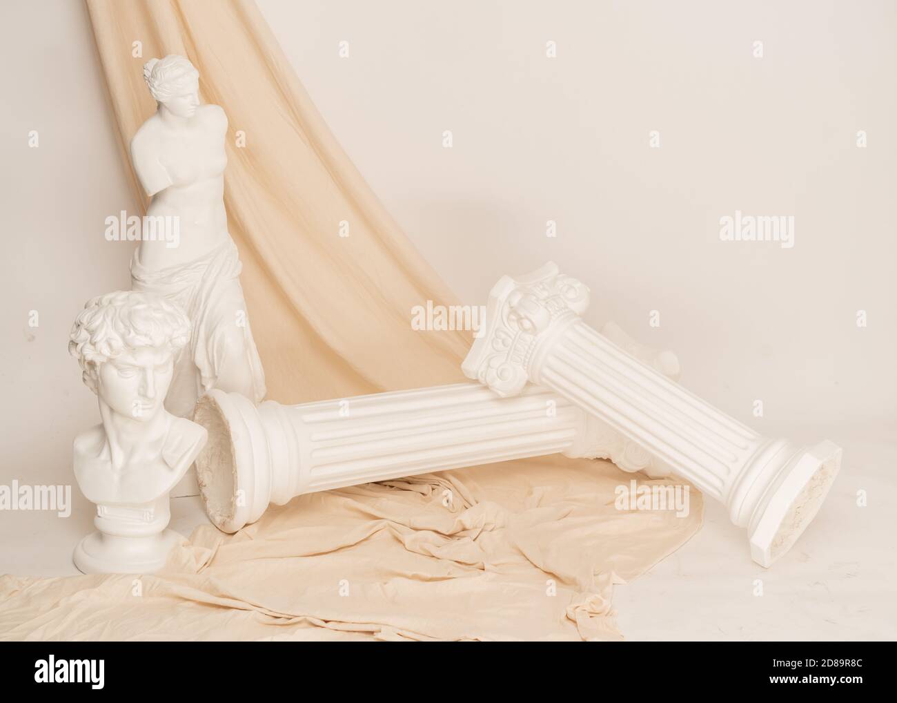 Renaissance epoch gypsum statues arranged with fabric on white ...