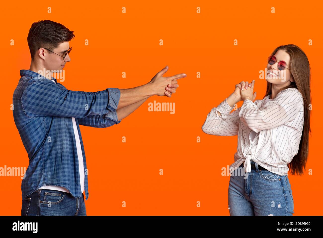 Cheerful millennial male and female in sunglasses making finger ...