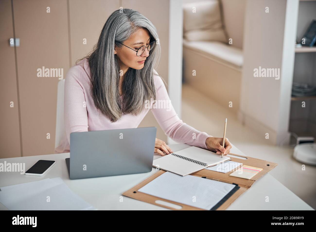 Adult beautiful woman in glasses writing notes on the sketchbook Stock ...