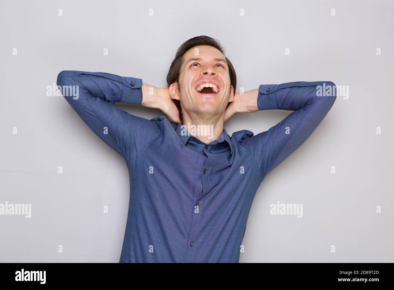 Portrait of carefree business casual man with hands behind head ...