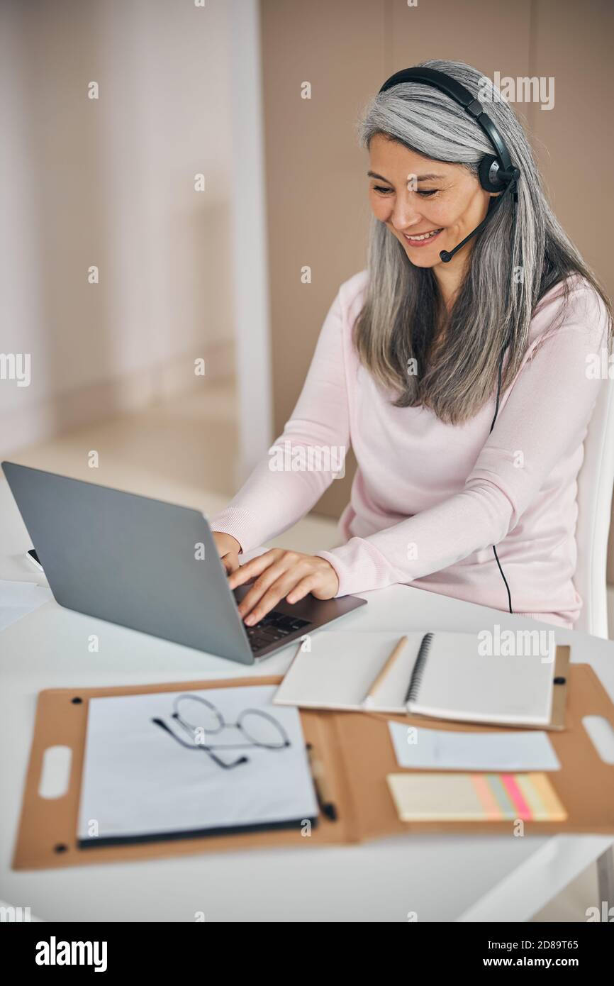Elegant female looking at the screen computer while typing text on ...