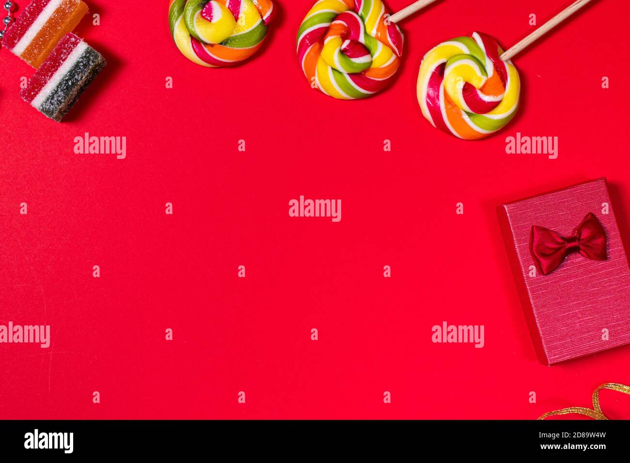 Gifts of sweets on a red background - candy lollipops and marmalade ...