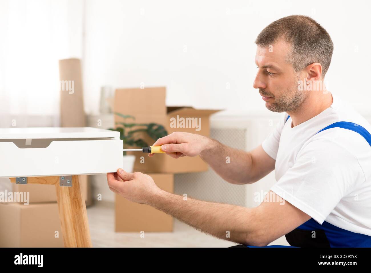 Professional Handyman Carpenter Assembling Table Using Screwdriver