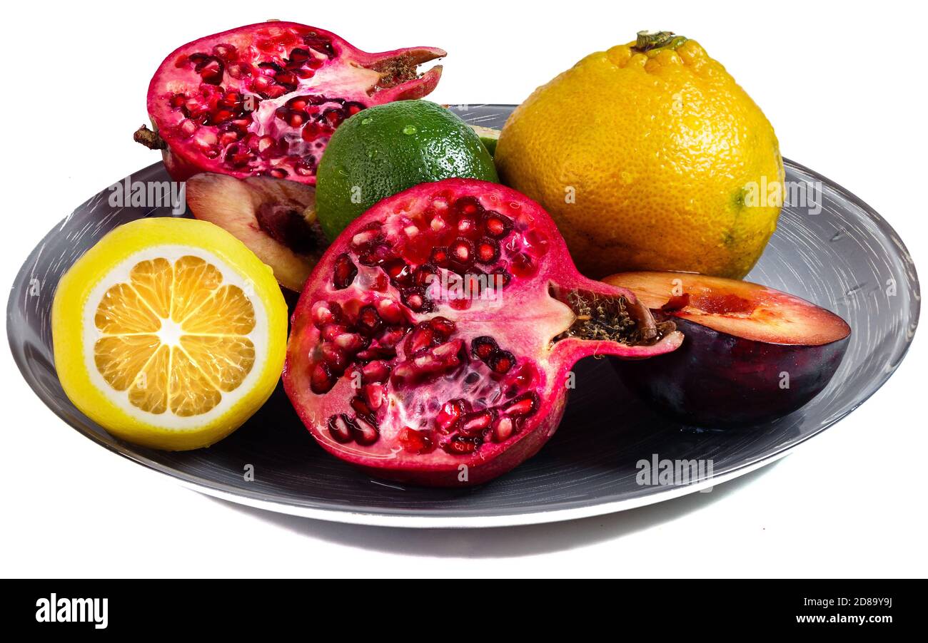 Colorful fruits on a dish on white background. Side view Stock Photo ...