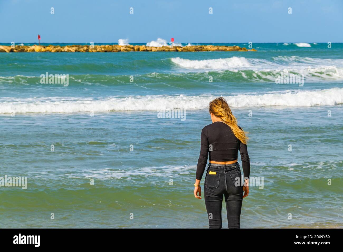 Back view young blonde woman at shore of beach, tel aviv, israel Stock ...