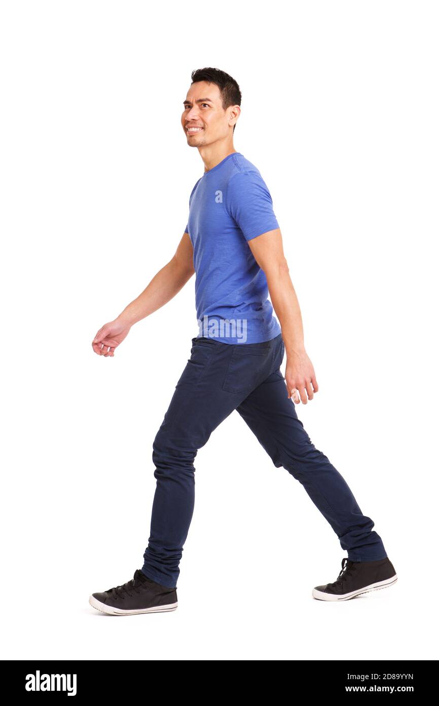 Full length side portrait of happy asian man walking over white ...
