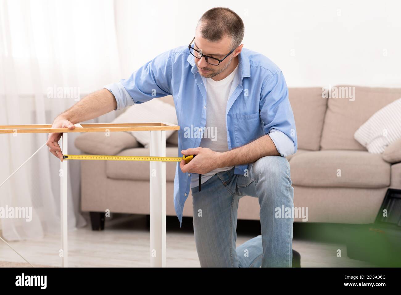 Man Assembling Shelf Using Measuring Tape Furnishing Living Room Stock ...
