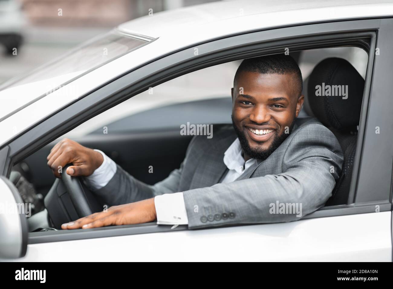 Happy businessman driving home after working day Stock Photo - Alamy