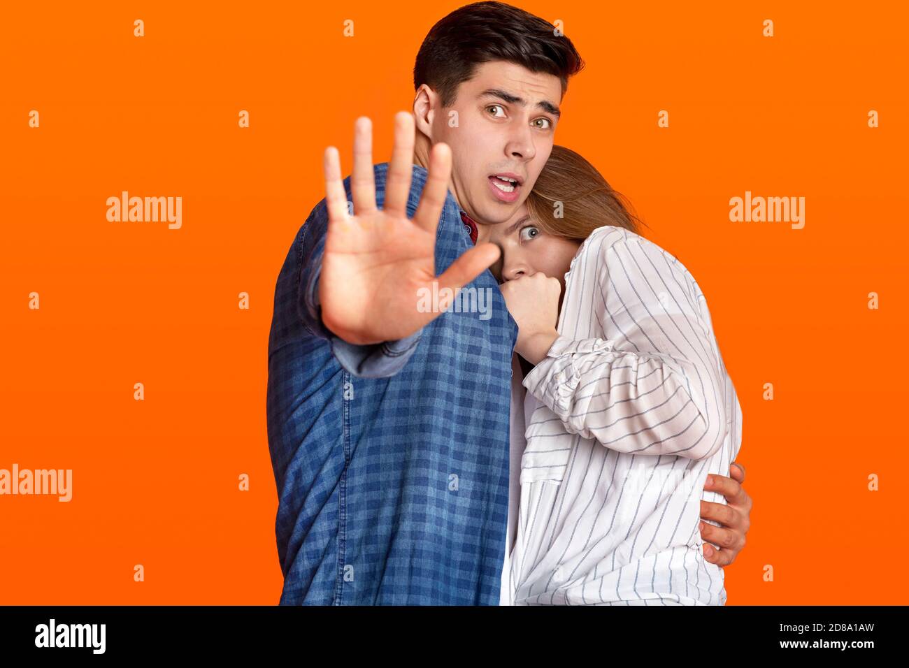 Do not come closer. Frightened female hiding at man chest, guy is ...