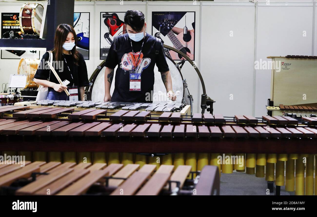 Shanghai, China. 28th Oct, 2020. Visitors try a percussion instrument ...