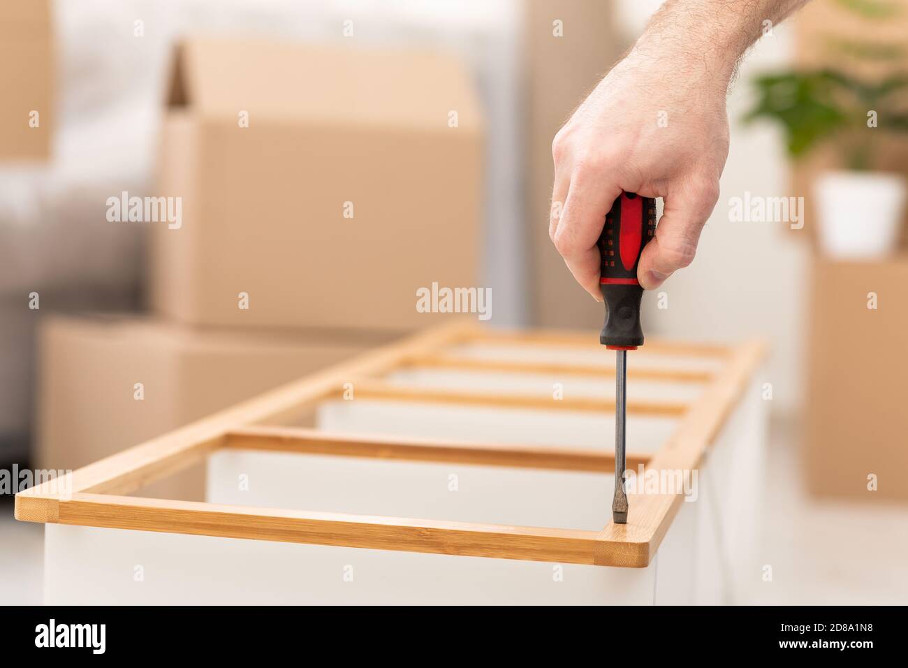 Unrecognizable Man Assembling Cabinet Shelf Using Screwdriver Tool