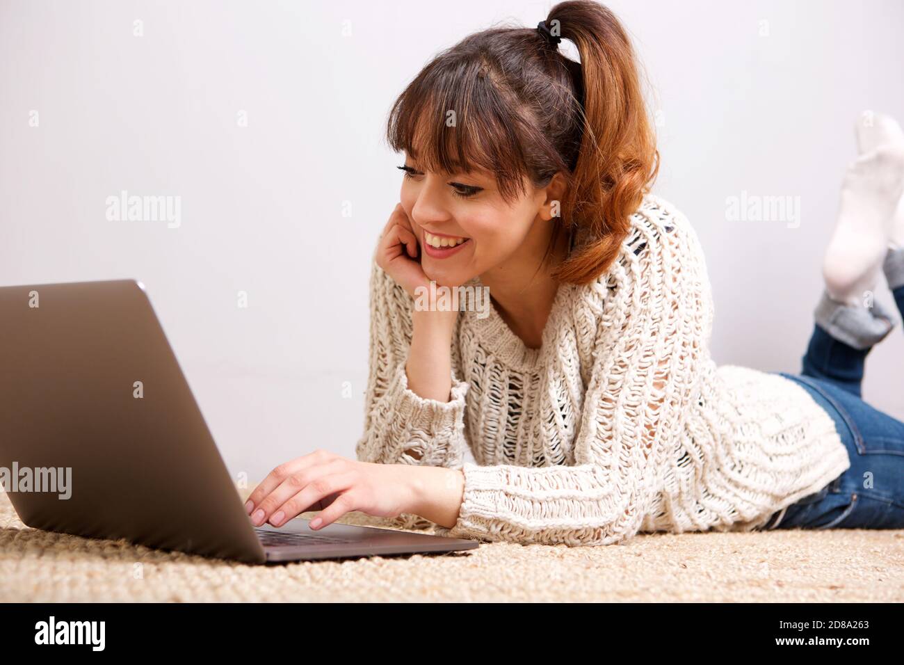 Portrait of young woman lying on floor with laptop computer Stock Photo ...