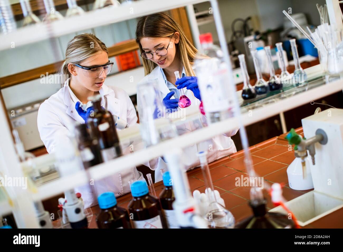 Cute female researchers in white lab coat working in the laboratory ...
