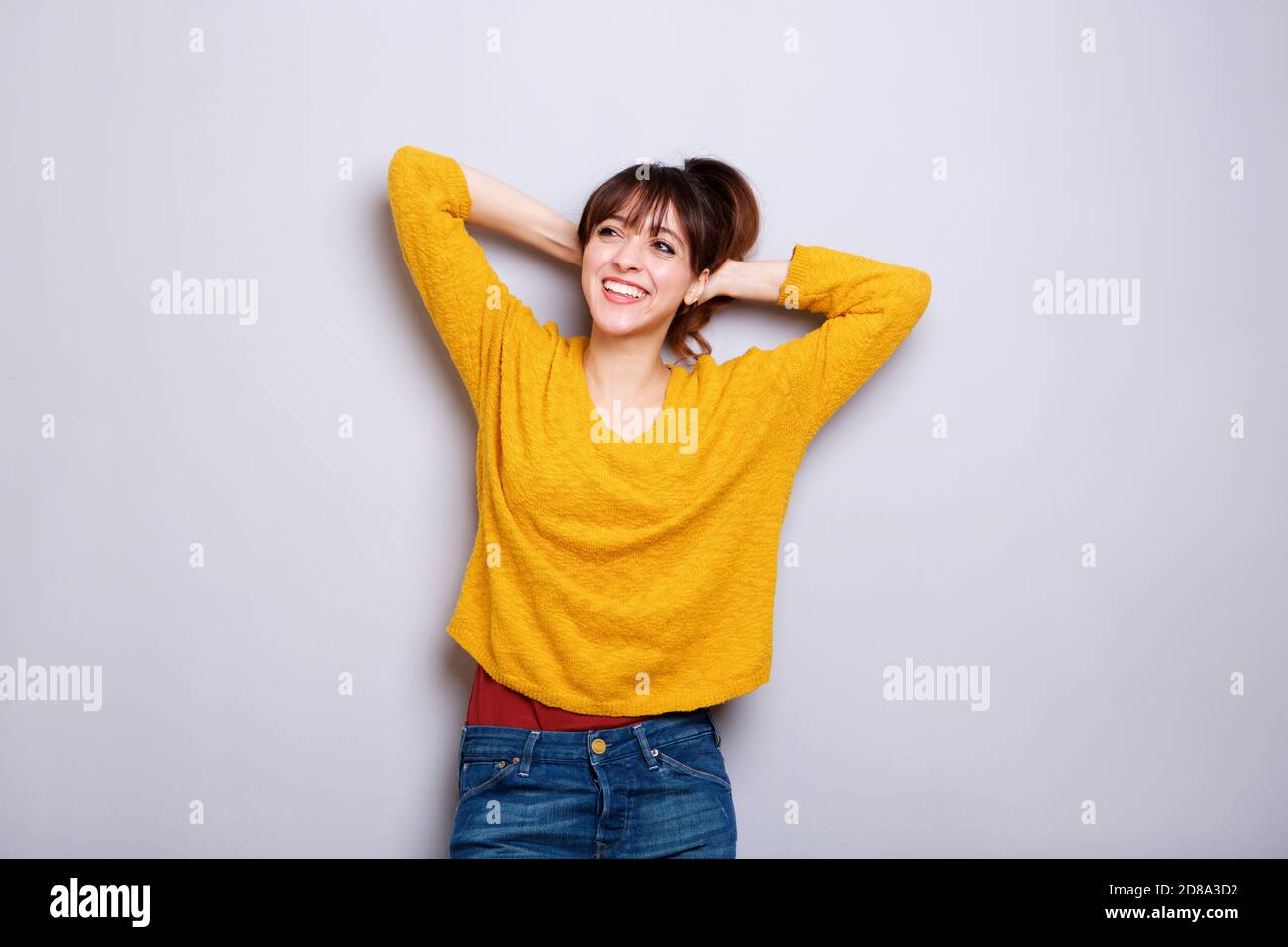 Portrait of happy young woman laughing with hands behind head Stock ...