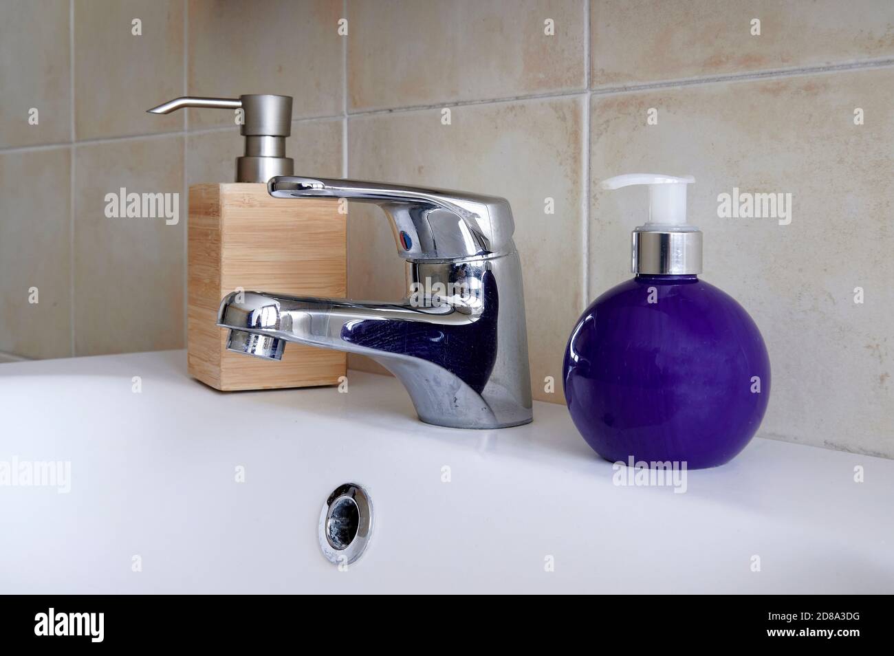 a sink tap and two soap contaneirs Stock Photo - Alamy
