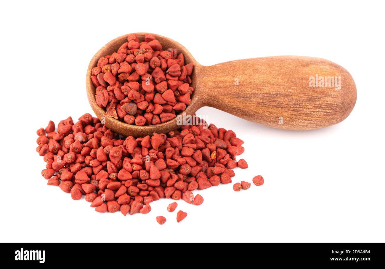 Annatto seeds in wooden spoon, isolated on white background. Achiote ...