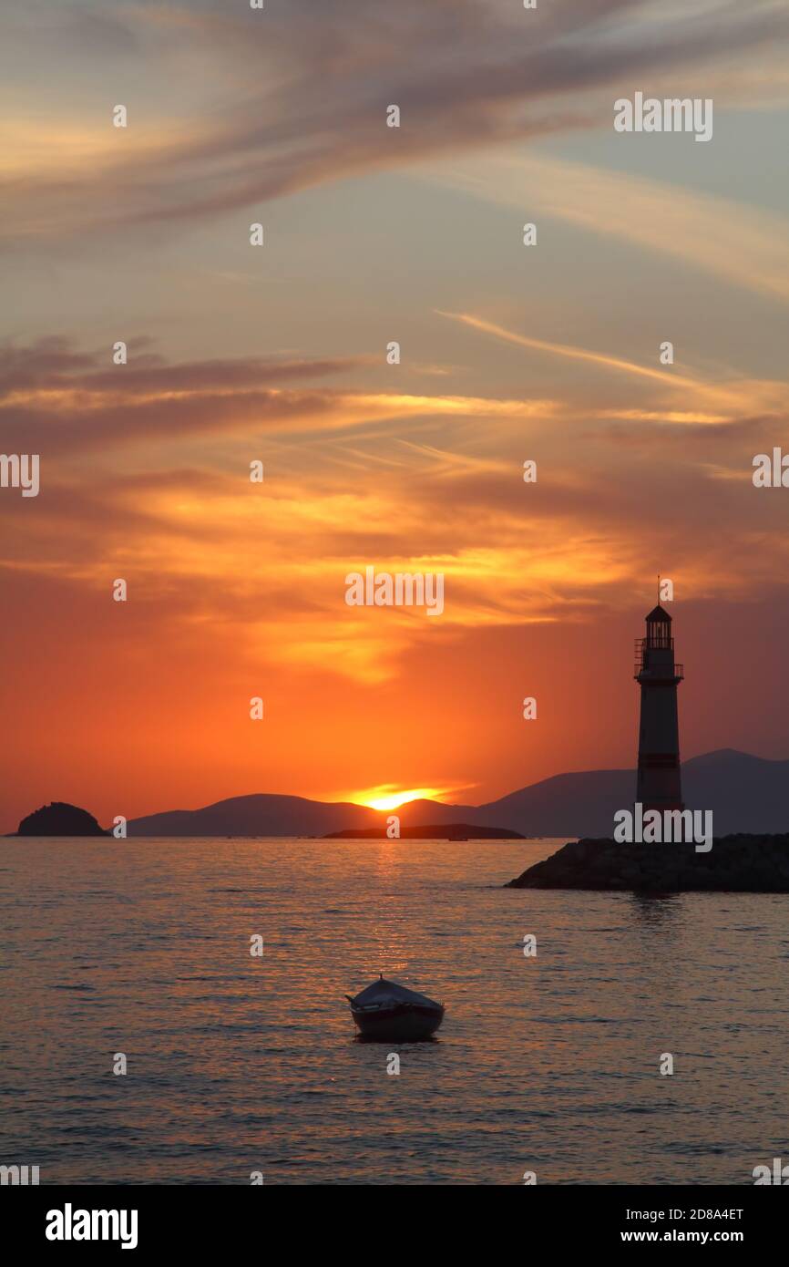 Seascape at sunset. Lighthouse on the coast. Seaside town of Turgutreis and spectacular sunsets ...
