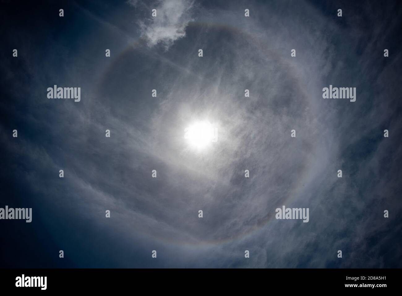 Low angle view of bright sun with halo effect and wispy clouds Stock ...