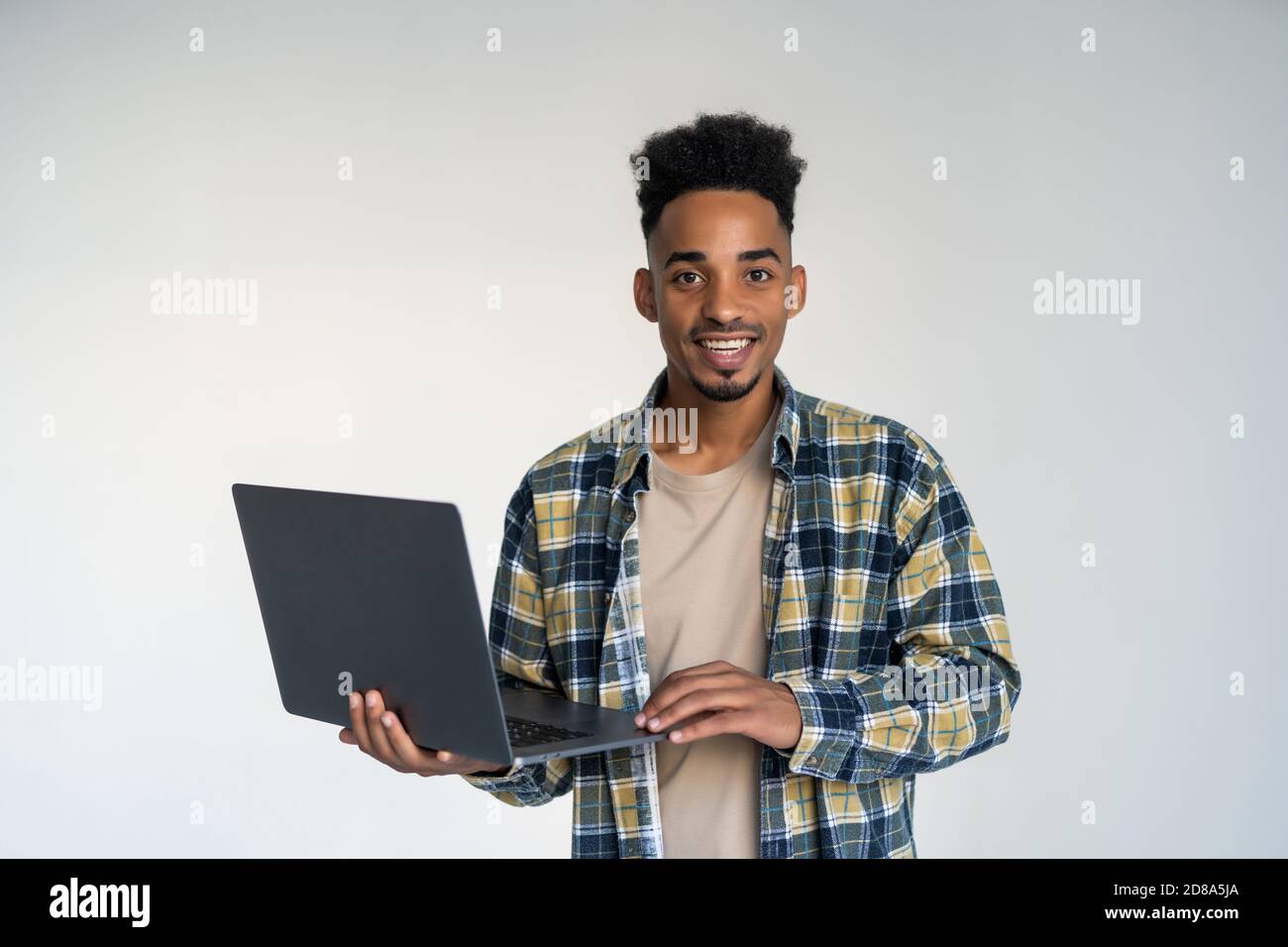 Young african american man using a laptop isolated on white background ...