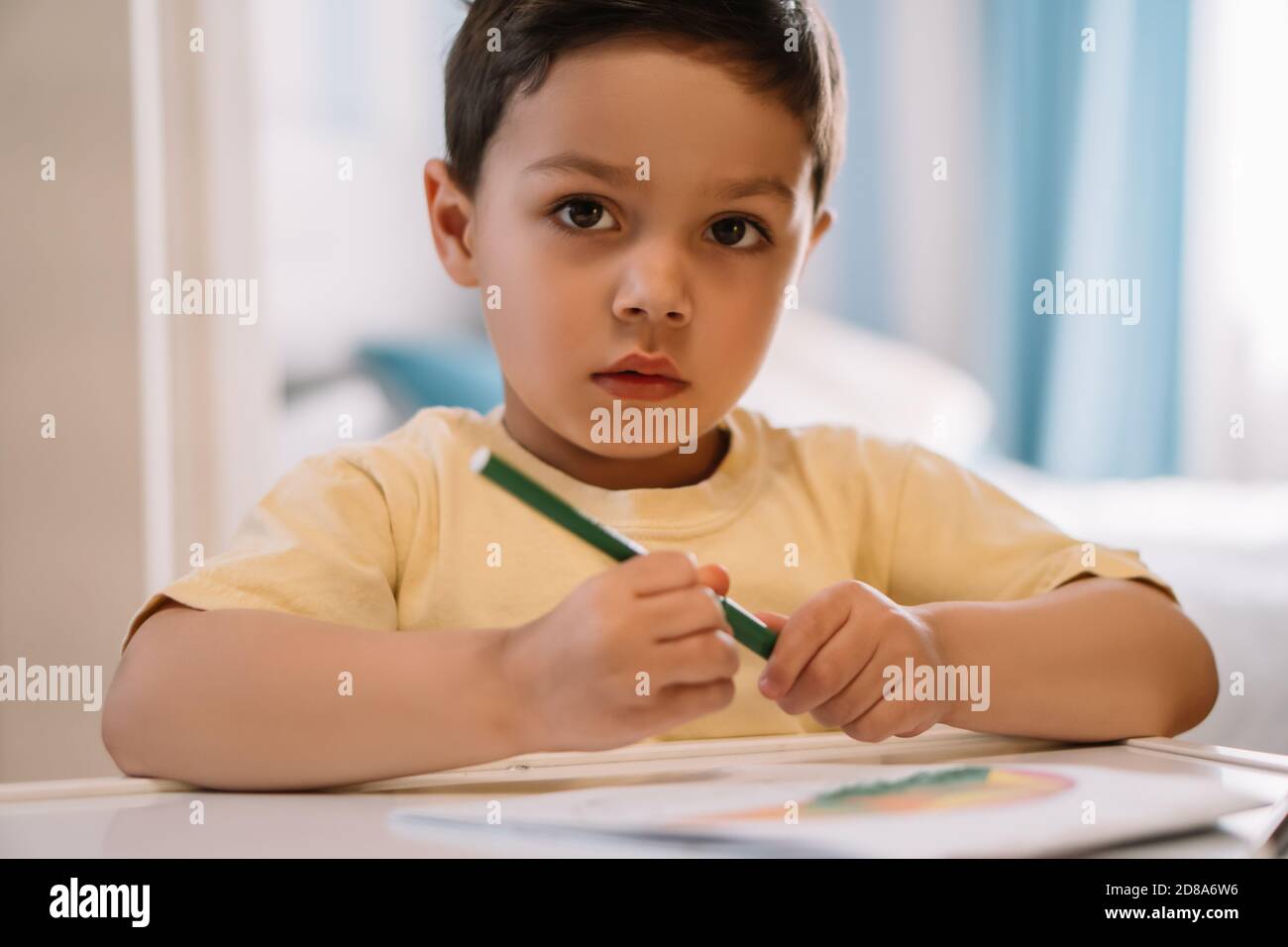 cute kid looking at camera while holding felt-tip pen Stock Photo - Alamy
