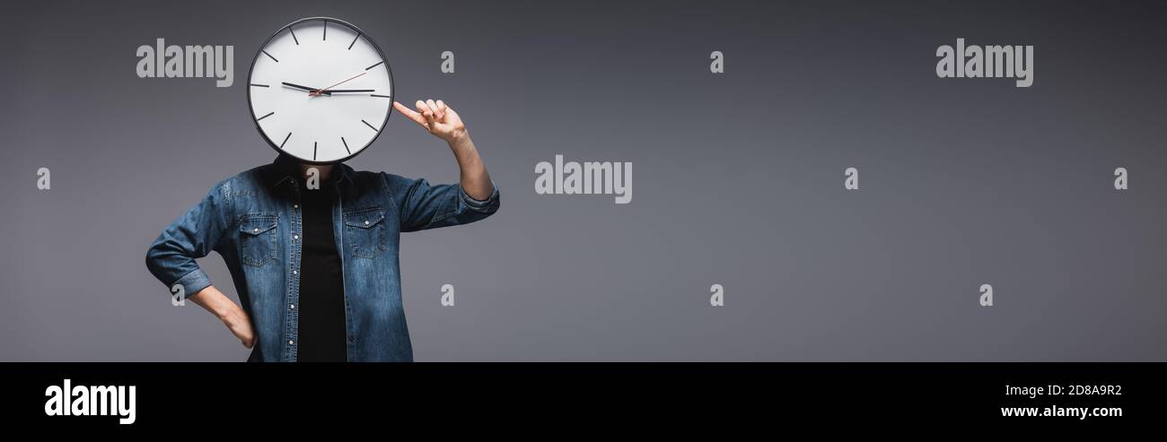 Panoramic orientation of man pointing with finger at clock on head on ...
