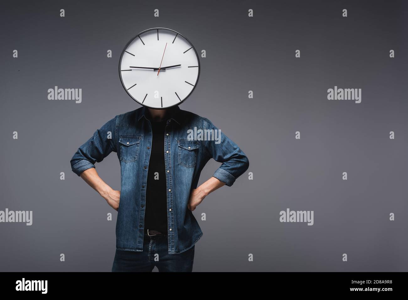 Man with clock on head and hands on hips on grey background, concept of ...