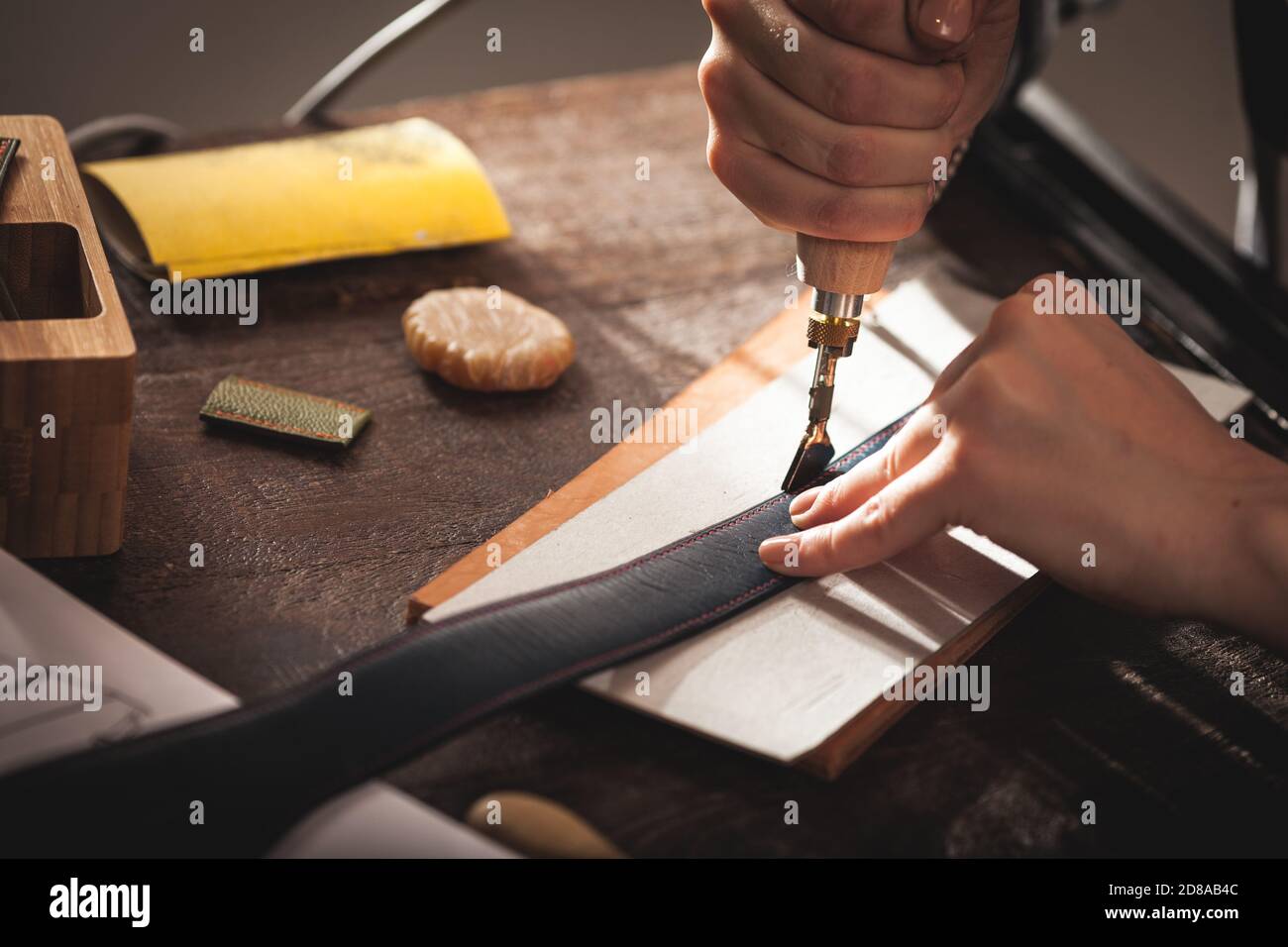 Leather handbag craftsman at work in a vintage workshop. Small business ...