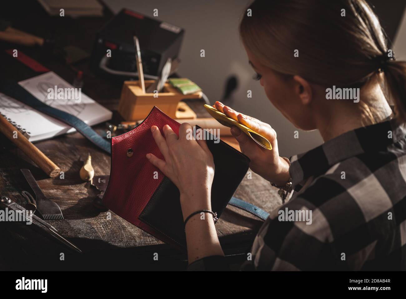 Leather handbag craftsman at work in a vintage workshop. Small business ...