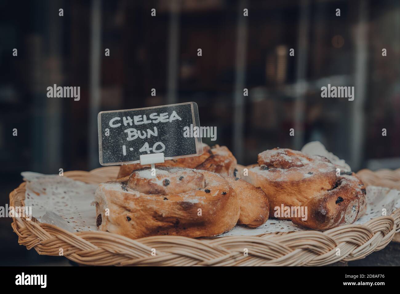 View through the window of fresh Chelsea buns on a retail display of a ...