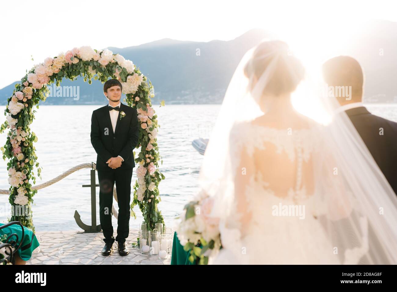 father leads the bride to the altar, where the groom is waiting for her ...