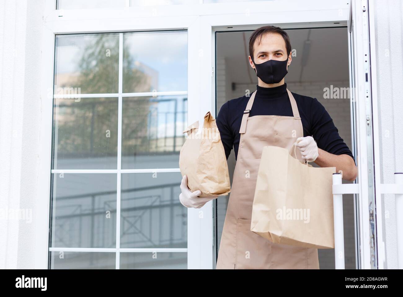 Delivery man holding paper bag with food, food delivery man in ...
