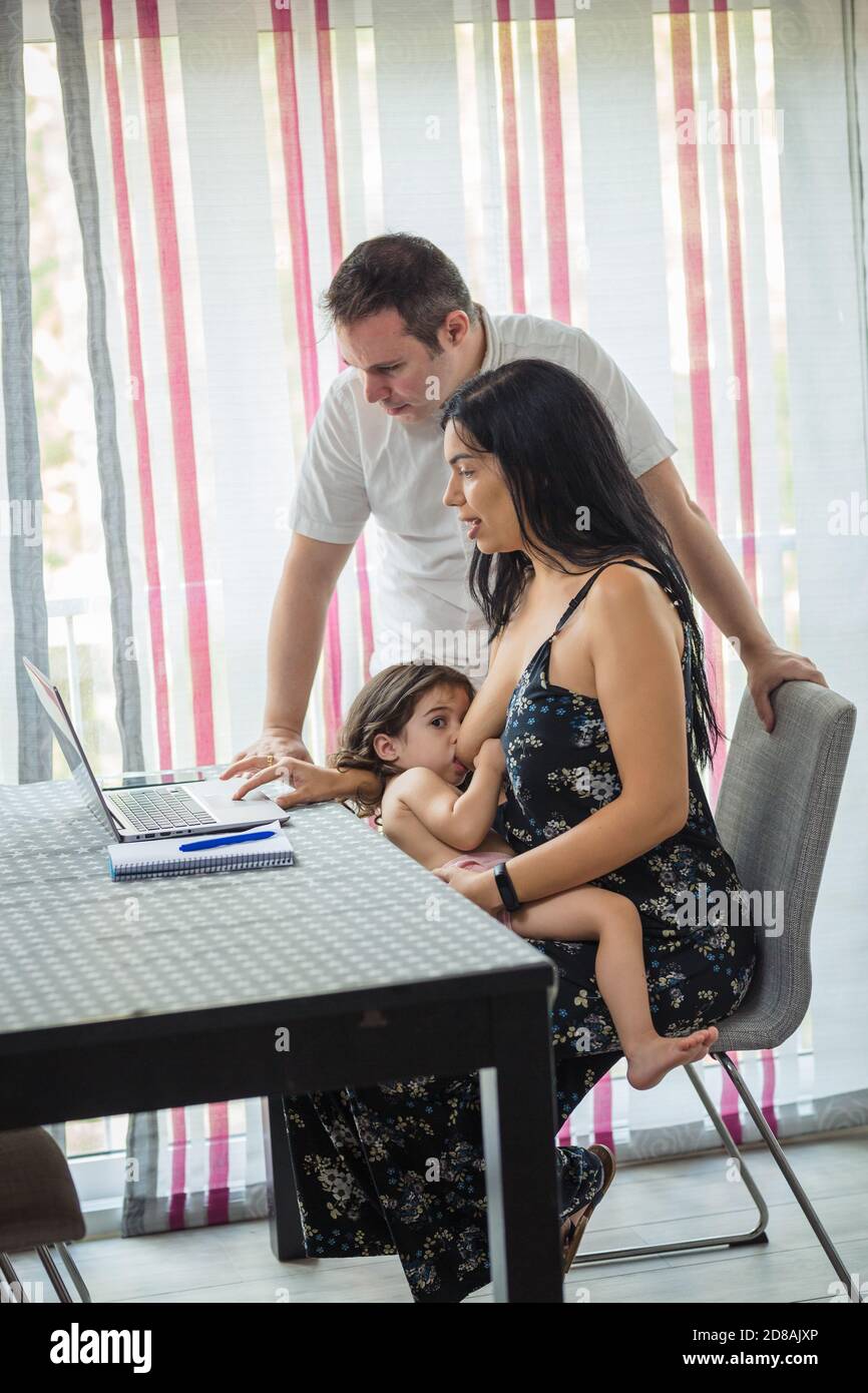 couple in the dining room are teleworking and watching laptop computers on the dining room table ...