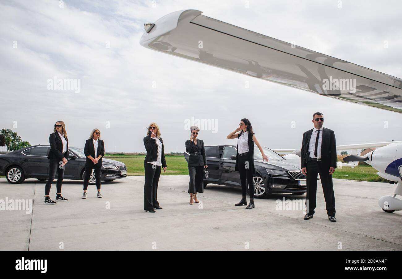 Famous female celebrity with bodyguards surrounded. VIP security agents ...