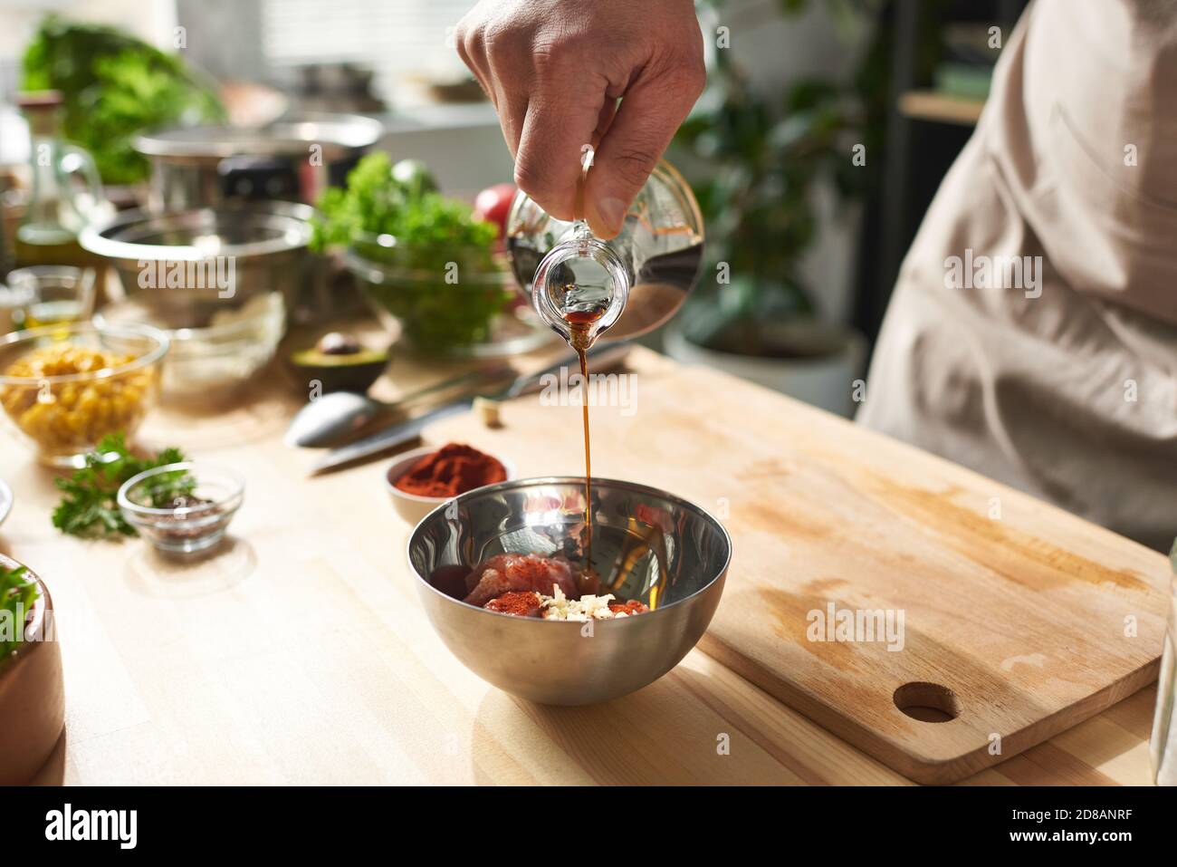 Close-up of chef pouring soy sauce into the bowl he making vegetable ...