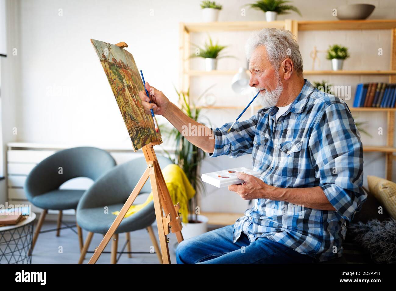 Smiling mature man painting on canvas at home Stock Photo - Alamy