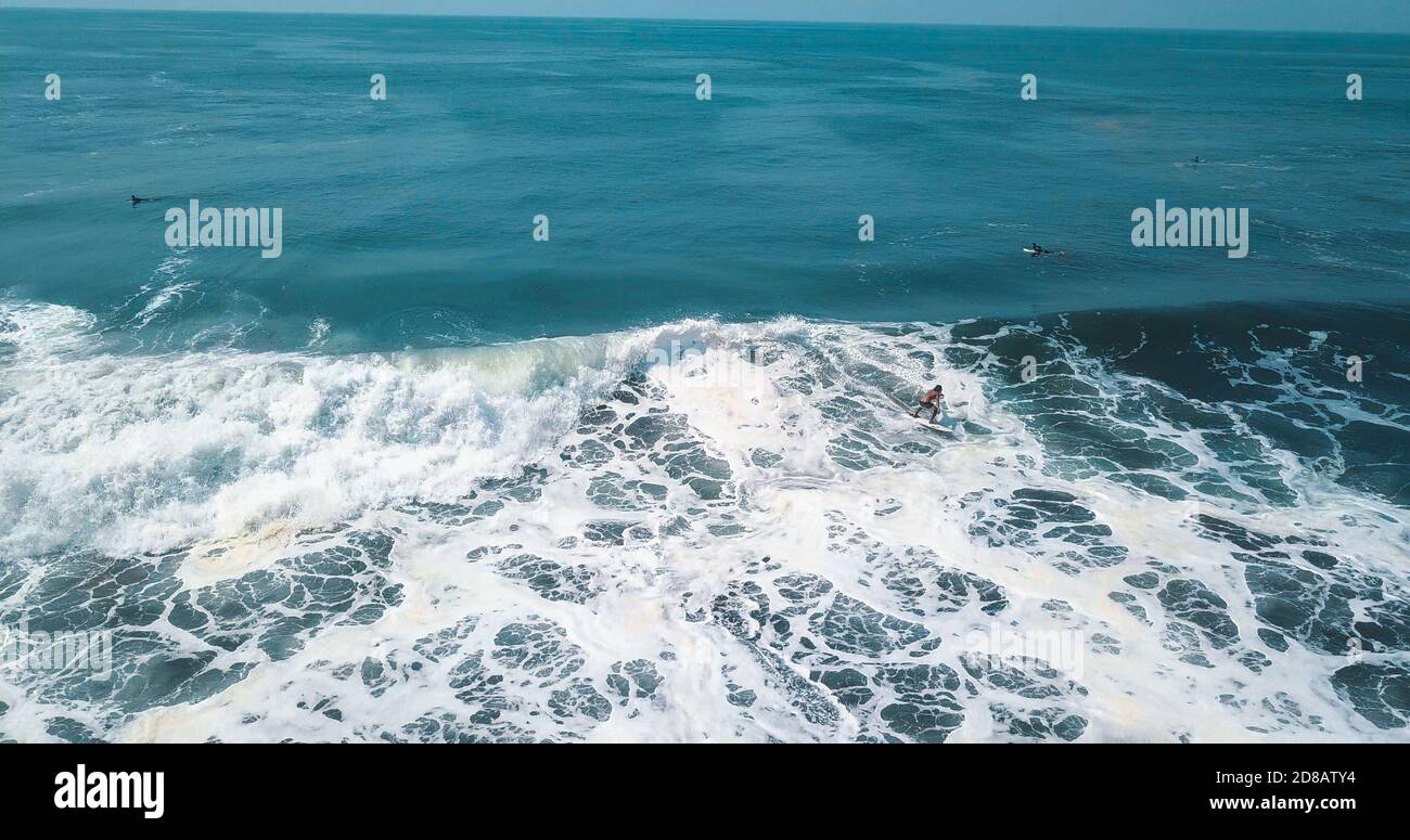 Mesmerizing shot of a surfer at the top of the wave in El Paredon beach ...