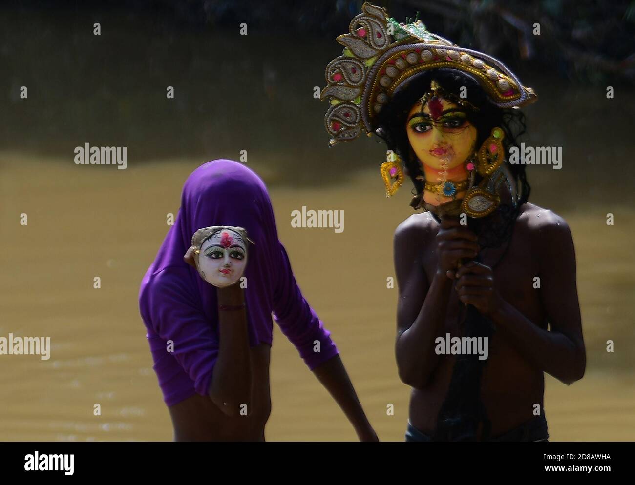 A child holds the head of an idol of the goddess Durga during an ...