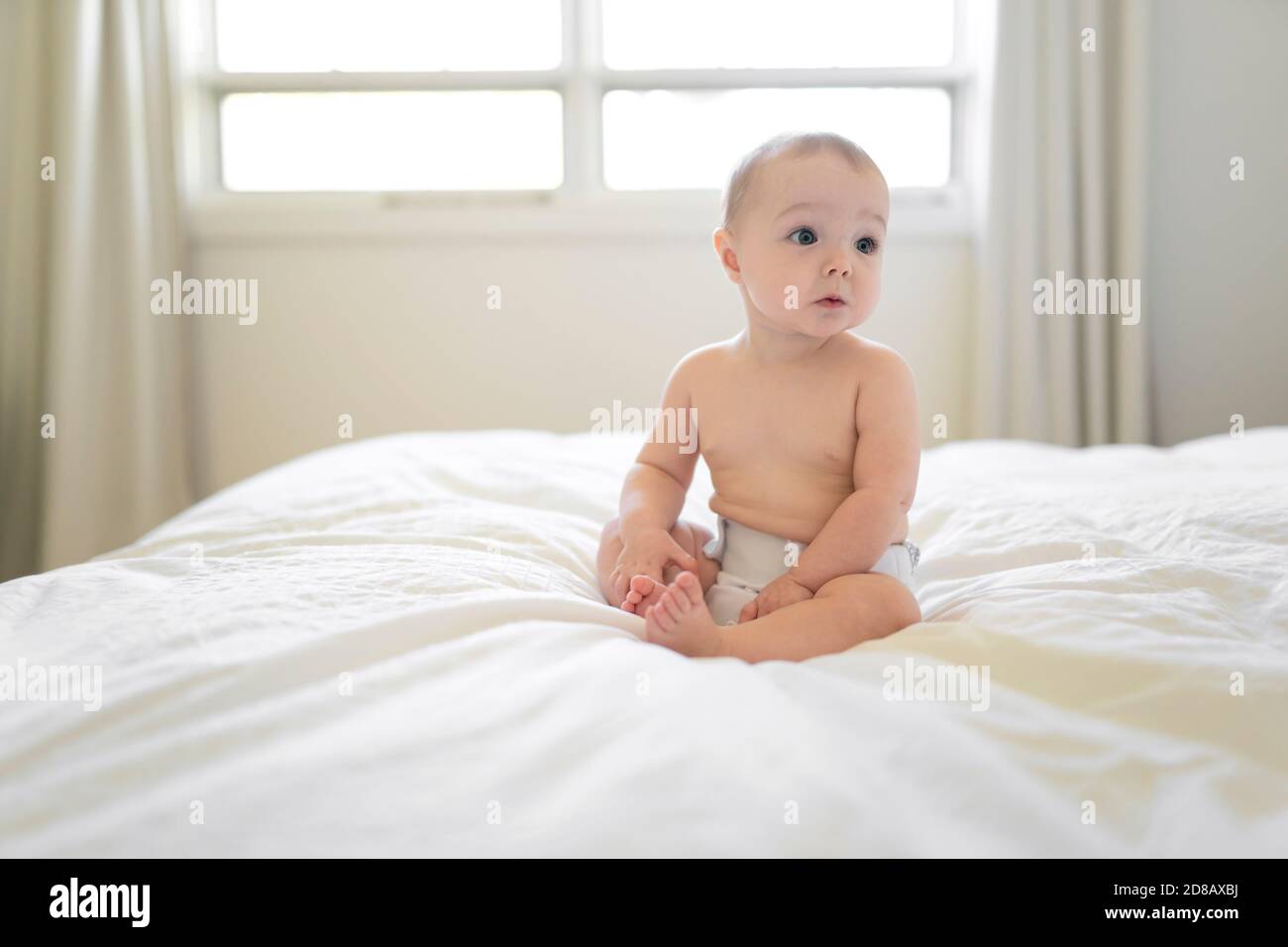 Portrait of a baby on the bed in parent bedroom Stock Photo - Alamy