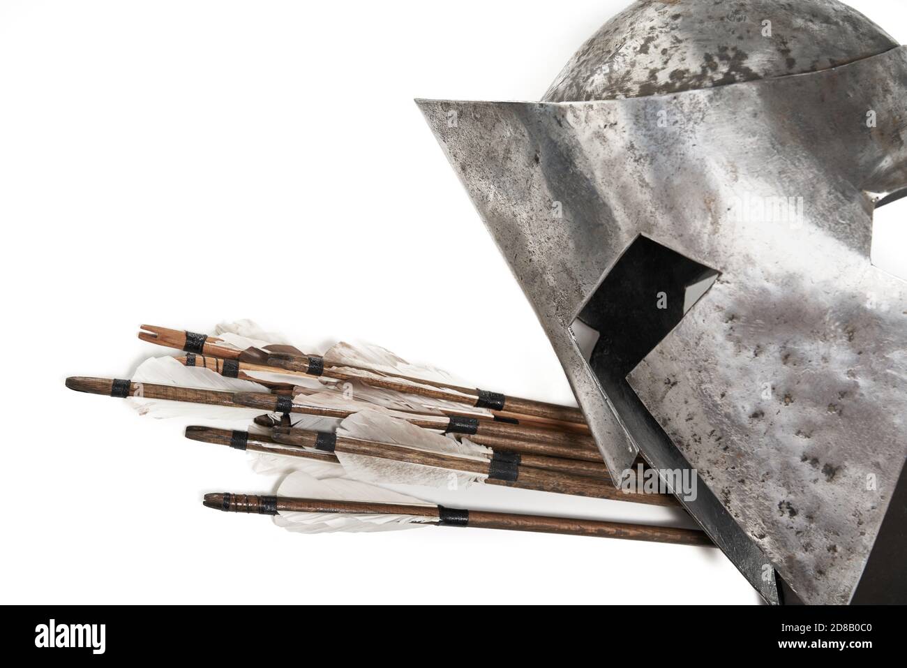 Close up side view of ancient iron silver helmet and wooden arrows with ...