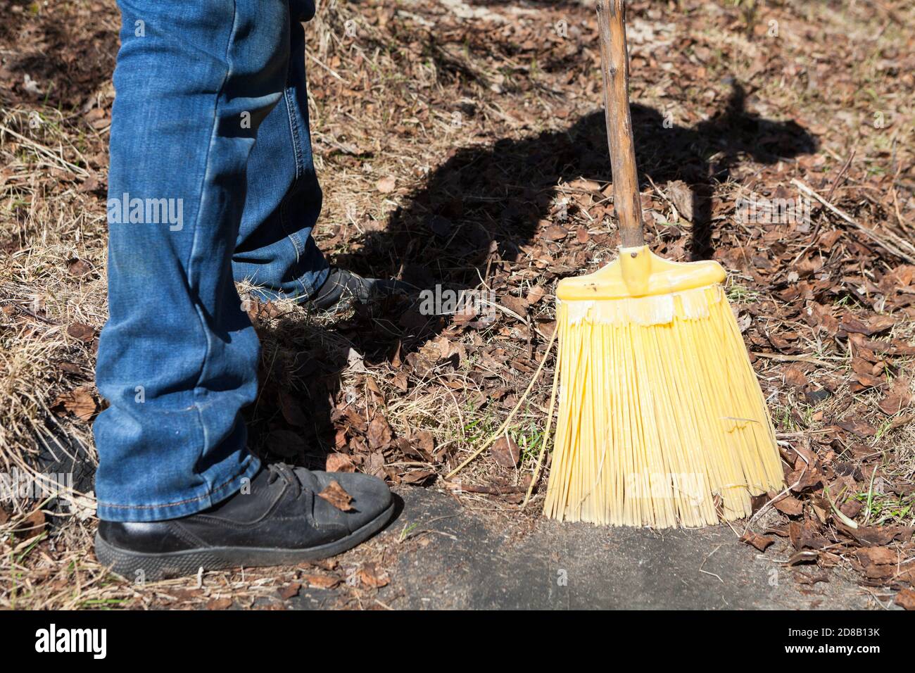 Sweeping dry leaves with plastic broom, close-up view Stock Photo - Alamy