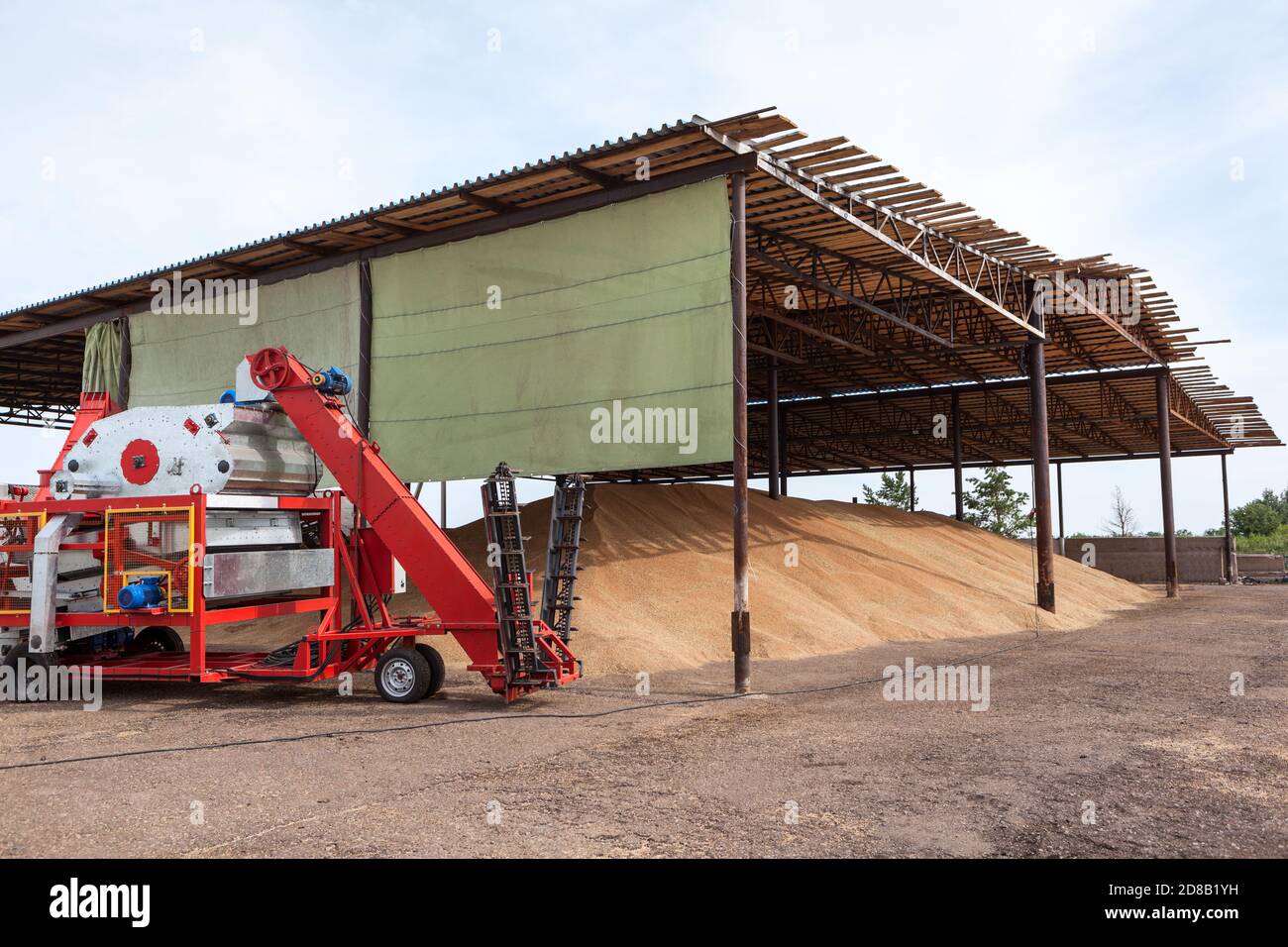 Grain warehouse from roof on poles, agricultural machinery during ...