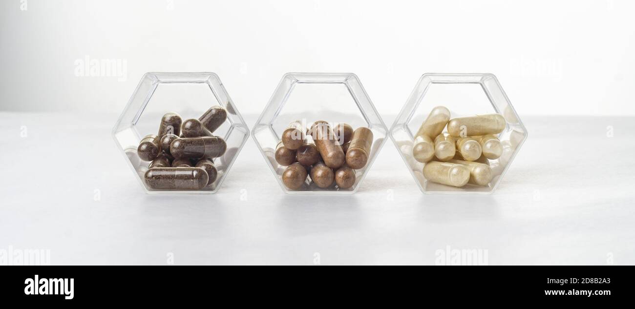 Various medical capsules and tablets in hexagonal transparent jars ...