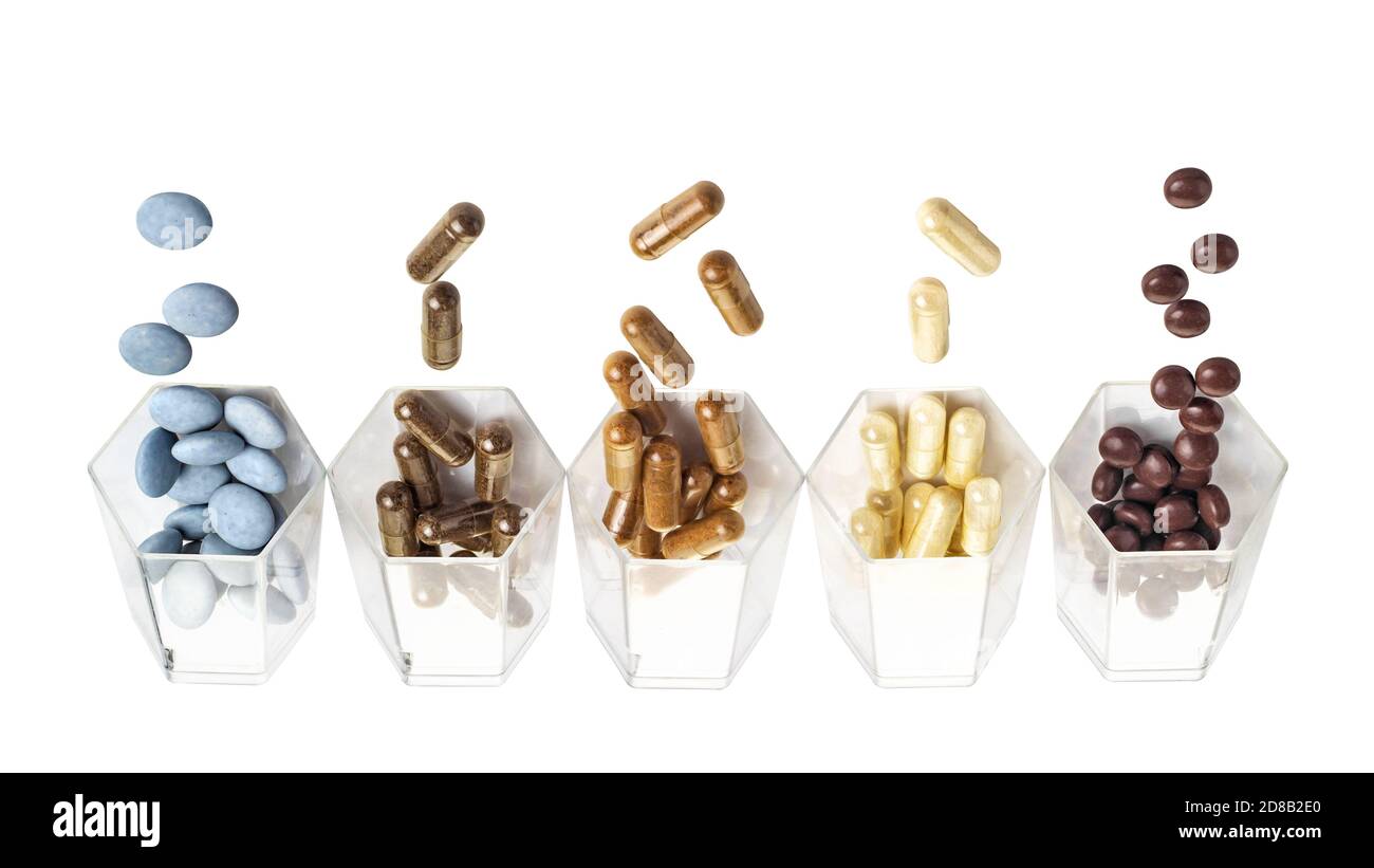 Variety of medical capsules and tablets spilled out of a glass ...