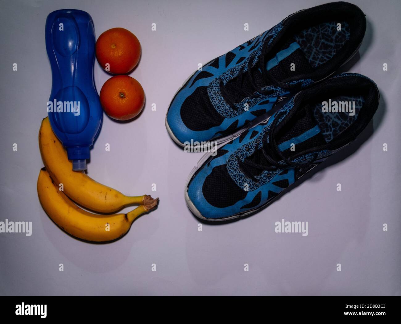 Top view of running shoes, healthy fresh fruits, and a bottle of water ...