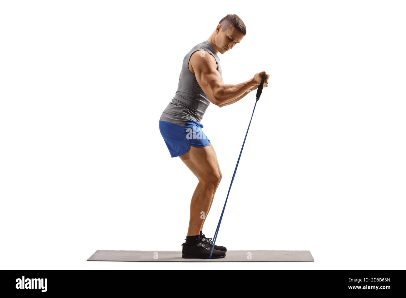 Full length profile shot of a muscular guy exercising with a resistance ...