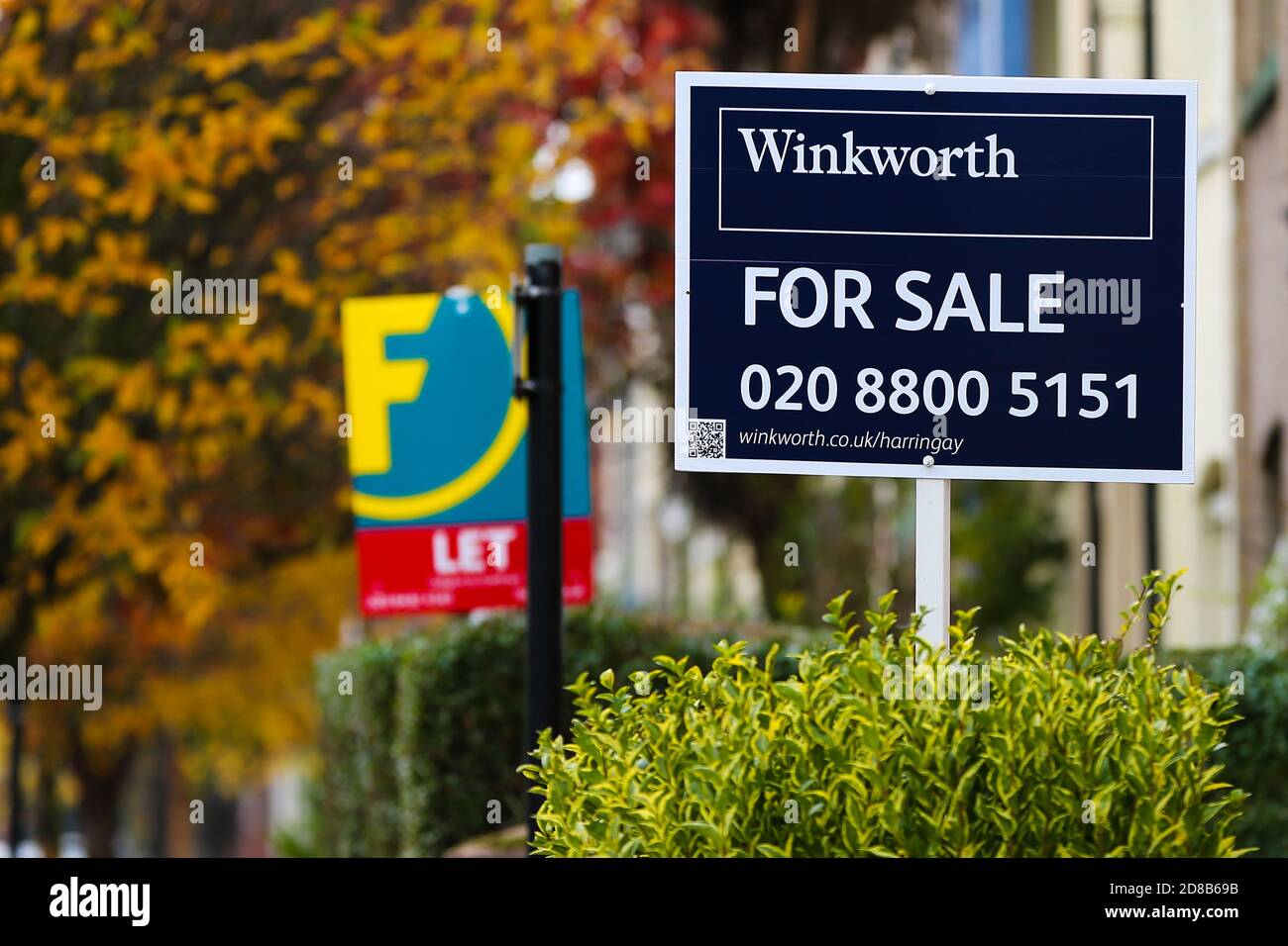A 'For Sale' and 'Let' estate agent boards are erected outside house in ...