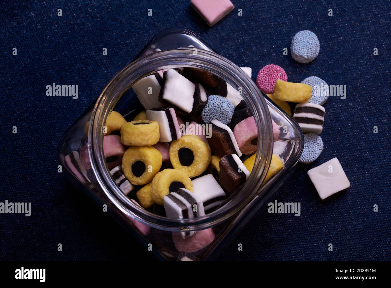 Open jar with sweets and candies in overhead view and dark background ...