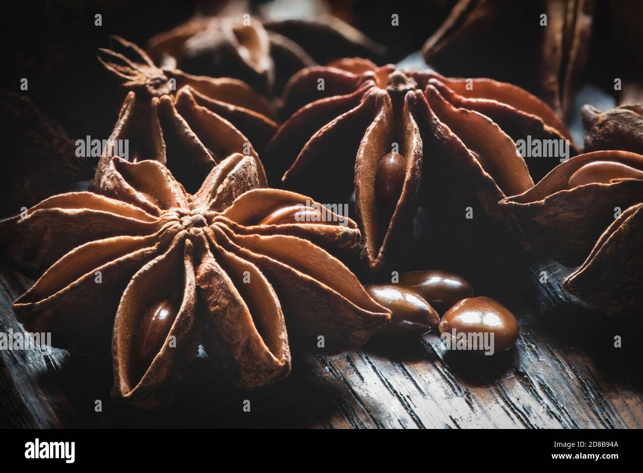 aromatic star anise fruits and seeds scattered on shabby wood surface ...