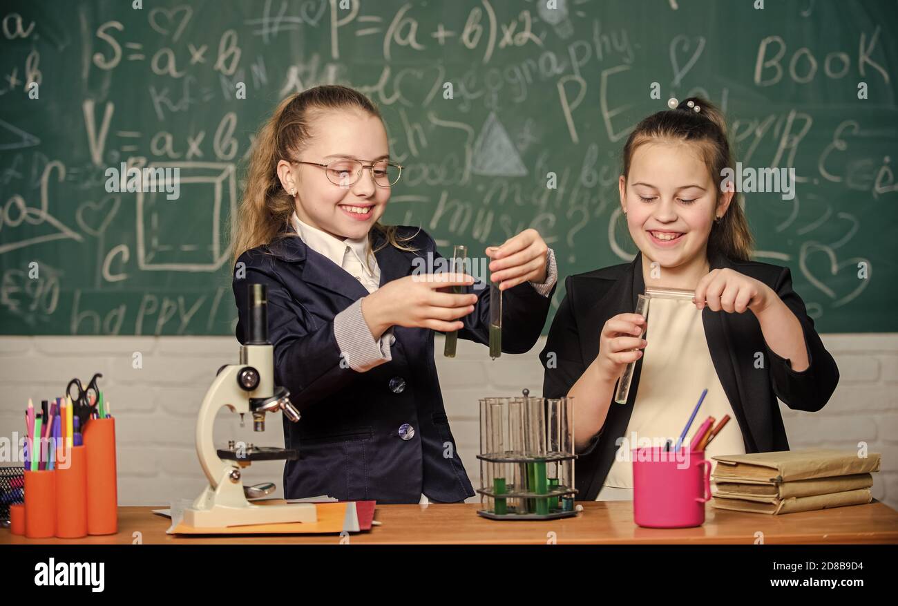 Little girls scientist work with microscope. Little girls in school lab ...
